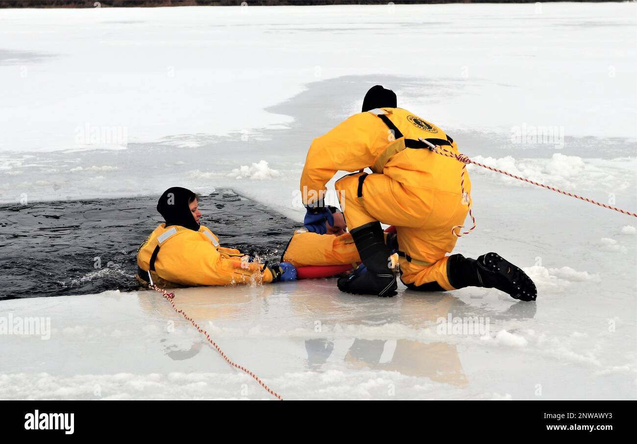 Firefighters wearing cold-water immersion protective suits hold surface ...