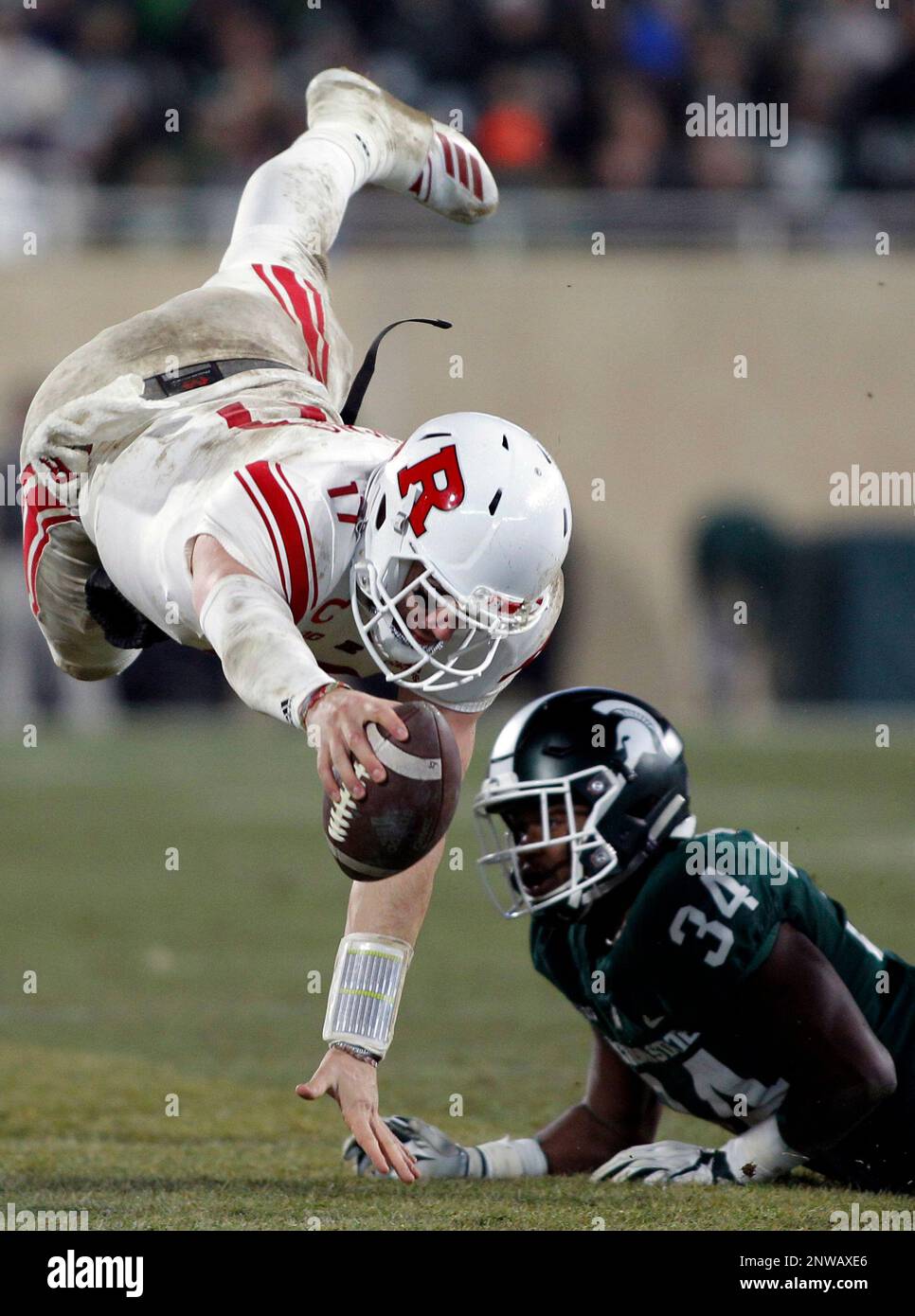Rutgers quarterback Giovanni Rescigno, left, dives over Michigan State ...