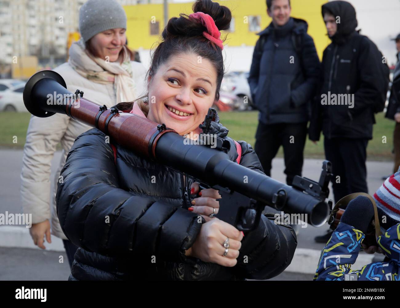 A woman poses with a grenade launcher at a weapons exhibition during ...