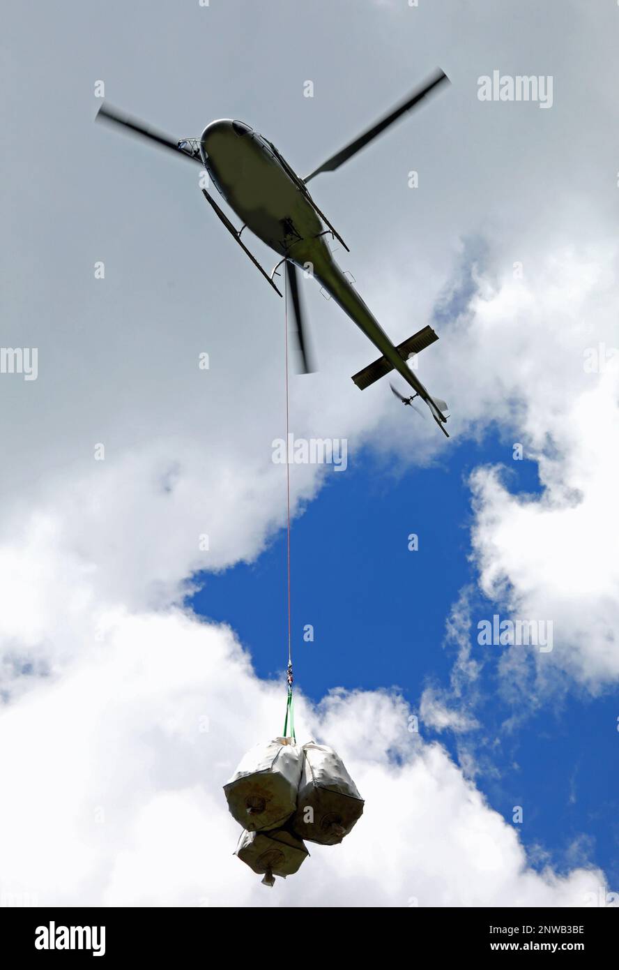 Helicopter in flight while transporting the goods attached to the winch ...