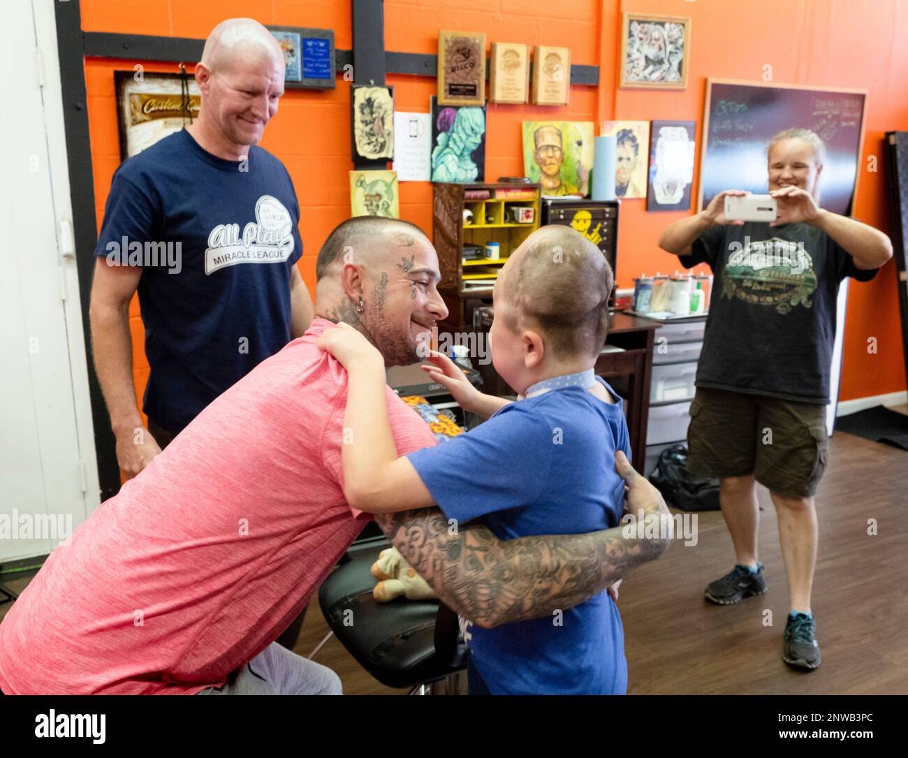 In this June 17, 2018, photo tattoo artist Mica Stewart gets a hug from ...