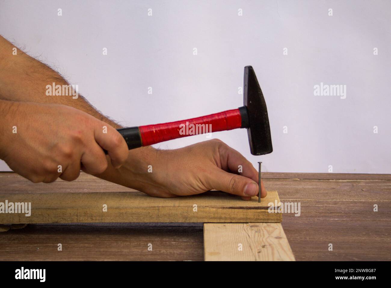 Image of a handyman craftsman's hands holding a hammer and nails while ...