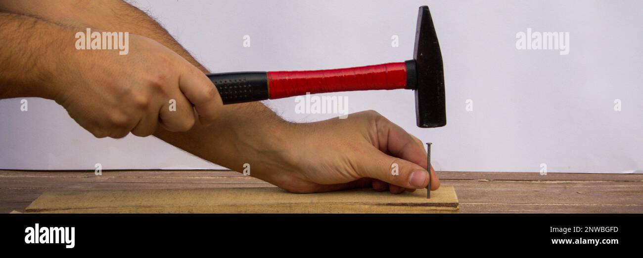 Image of a handyman craftsman's hands holding a hammer and nails while ...