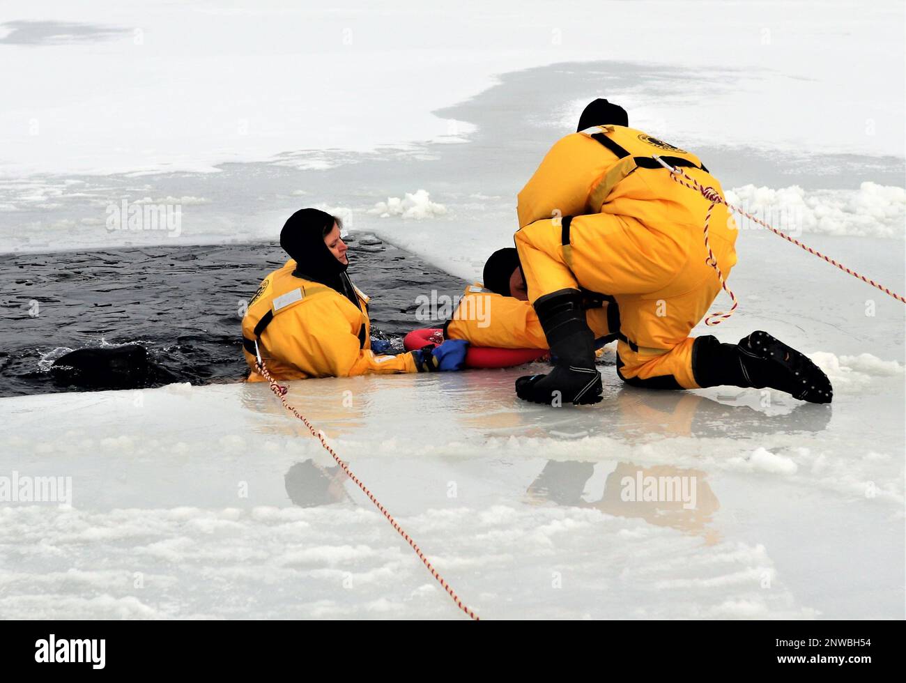 Firefighters wearing cold-water immersion protective suits hold surface ...