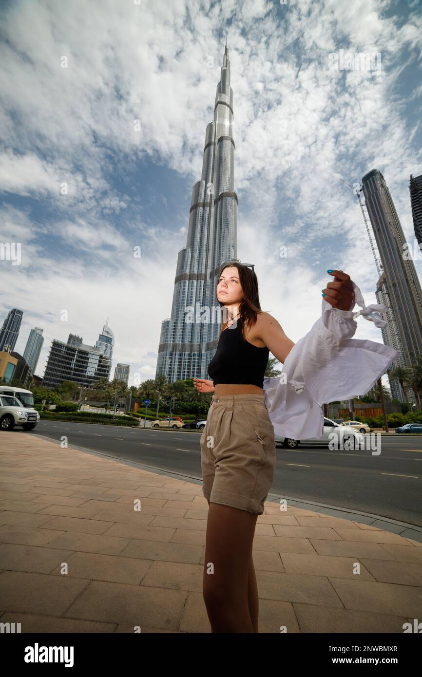 DUBAI, UAE . A happy young woman enjoys the view in front of the Burj ...