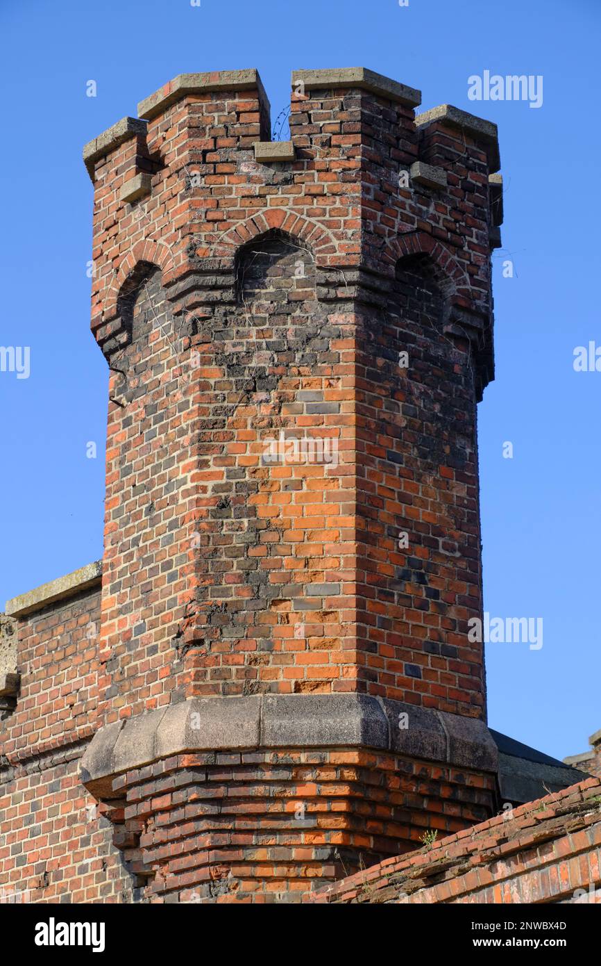Crenellated fortress tower made red brick against blue sky background ...