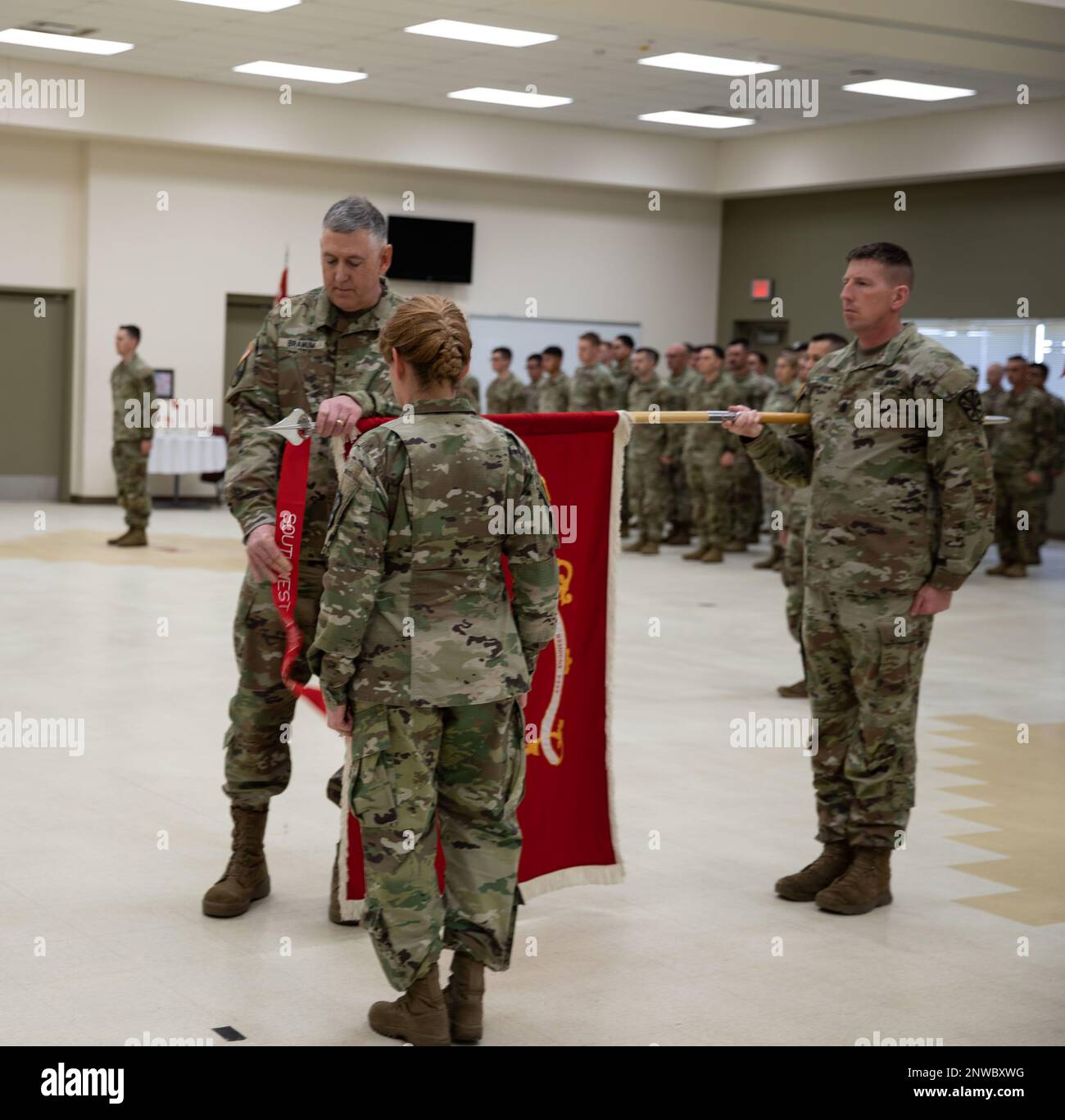 Brig. Gen. Lonnie Branum attaches the meritorious service ribbon to the ...