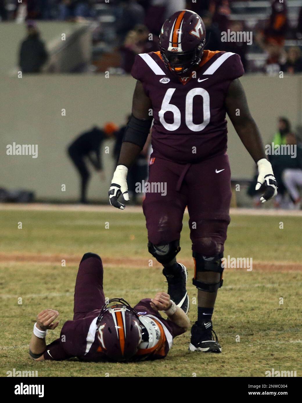Virginia Tech offensive lineman Silas Dzansi (60) stands over injured ...