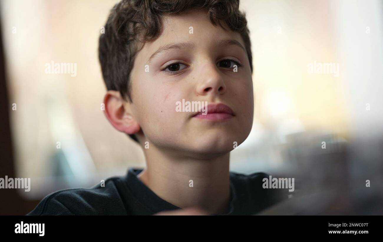 One small boy chewing food at lunch table. Candid closeup face of ...