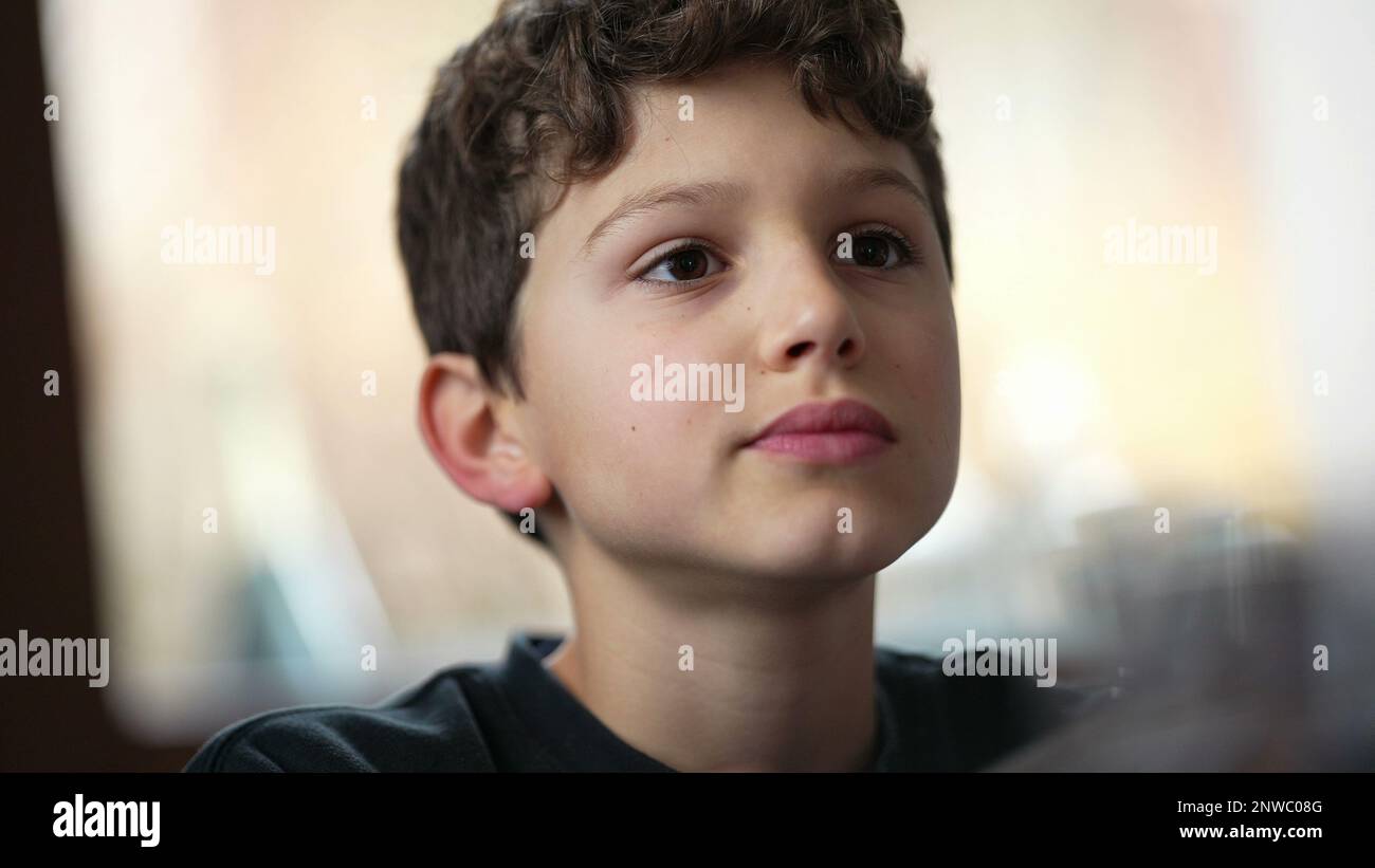 One small boy chewing food at lunch table. Candid closeup face of ...