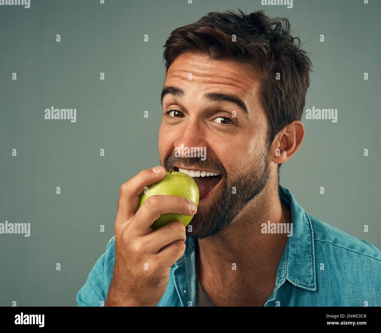 Snacking the healthy way. Studio portrait of a handsome young man ...