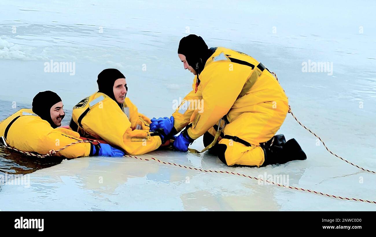 Firefighters wearing cold-water immersion protective suits hold surface ...
