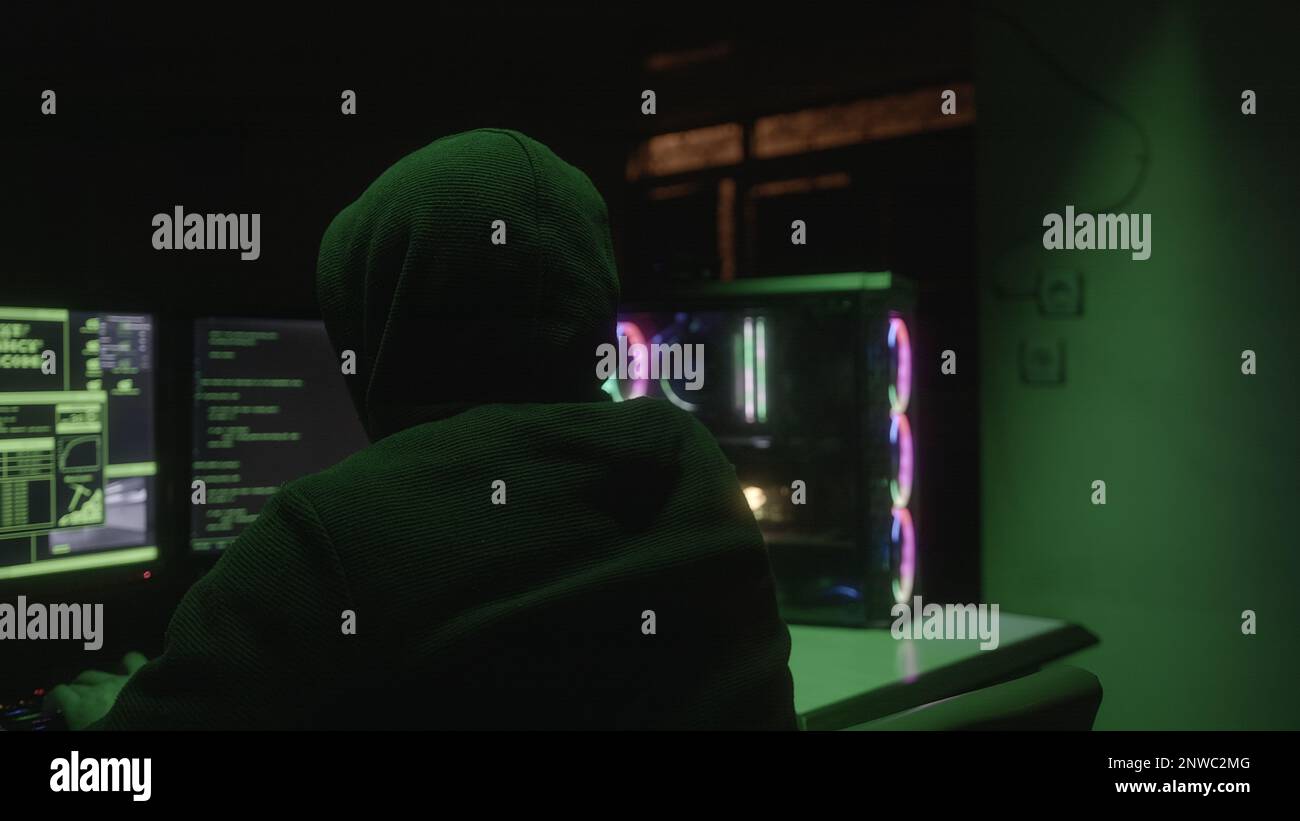 Hacker in Hoodie Hacking Away with Back Turned Stock Photo - Alamy
