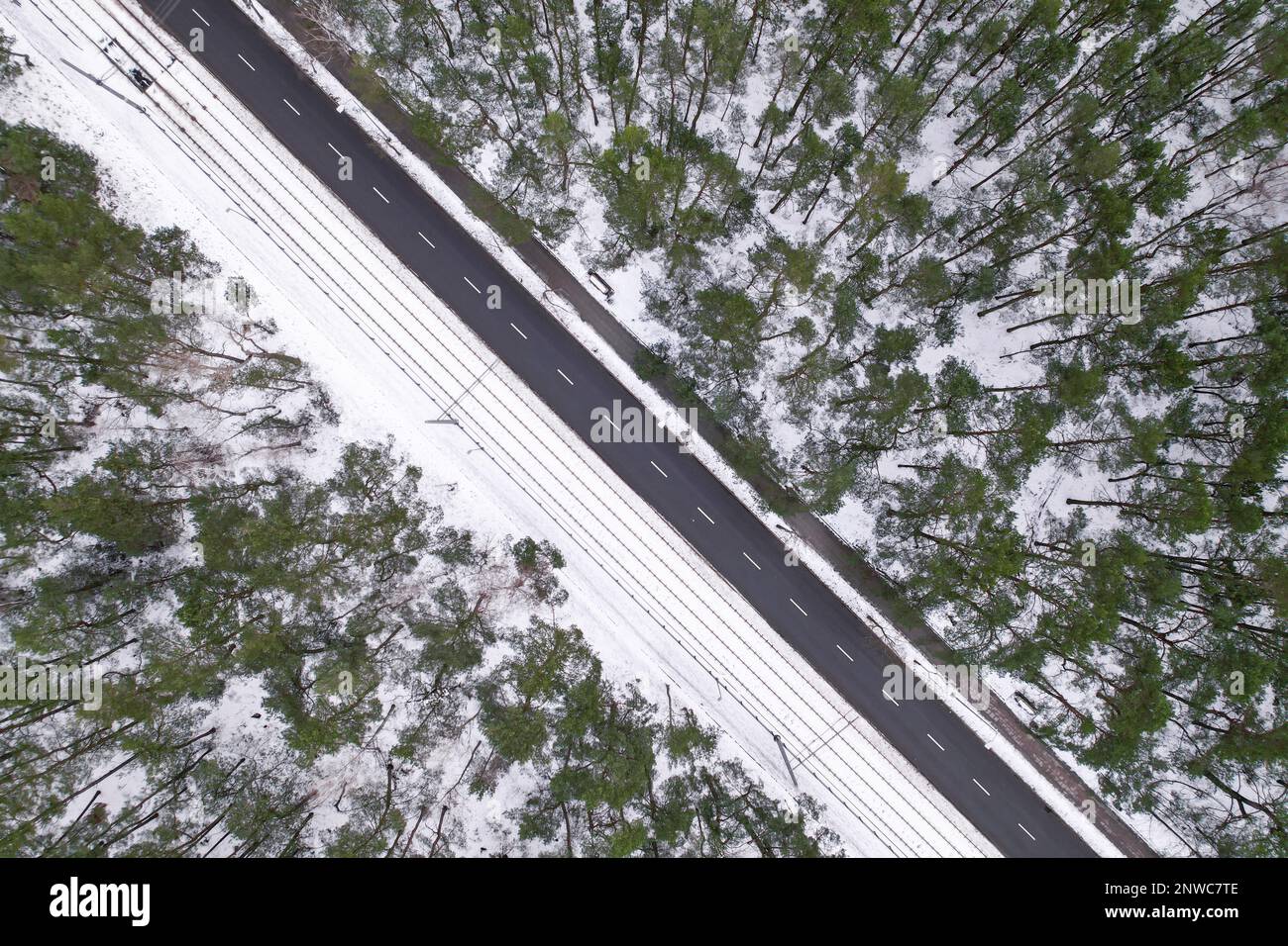 Aerial view on road in winter time, road surrounded with forest trees ...