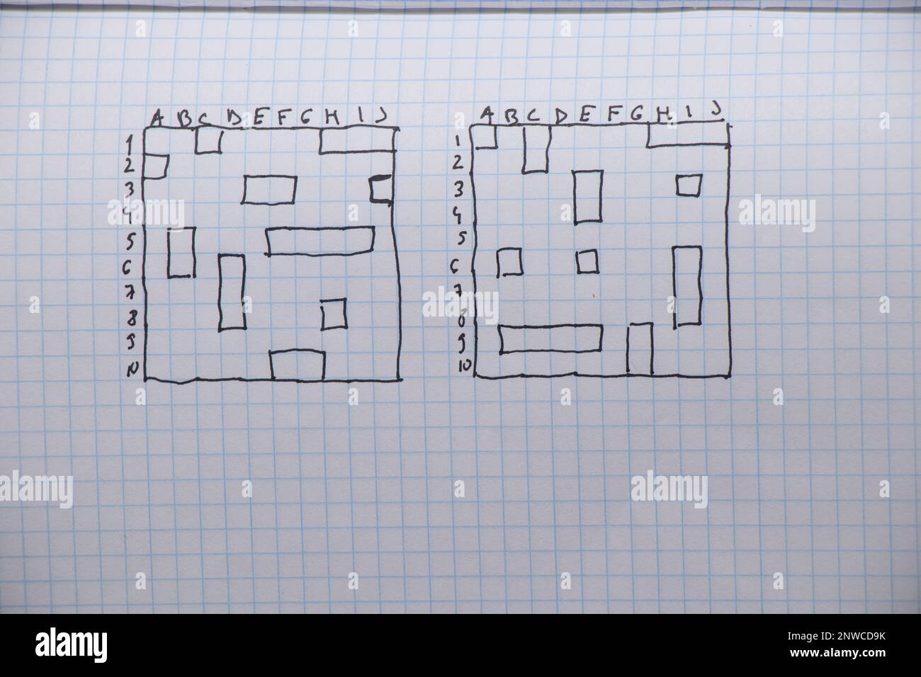 sea battle game, hand-drawn with a pen in a white notebook, rest on a ...