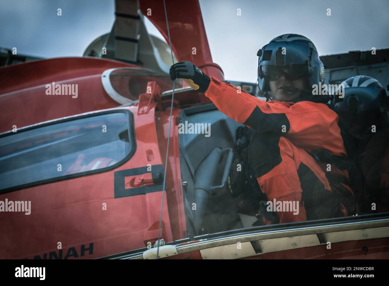 A U.S. Coast Guard Eurocopter MH-65 Dolphin Helicopter crew member from ...
