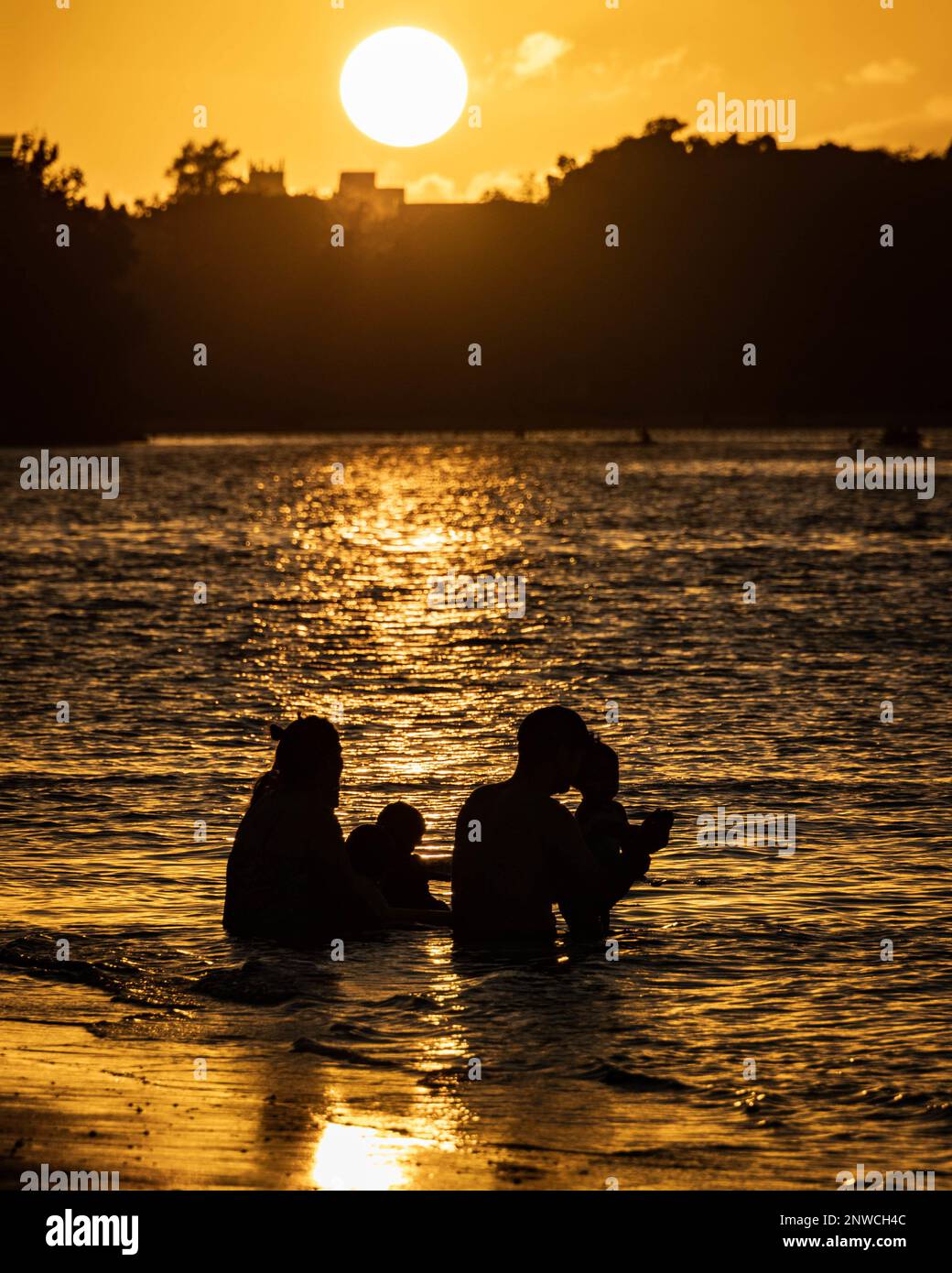 Local residents of Guam paddle and swim in the Pacific Ocean at ...