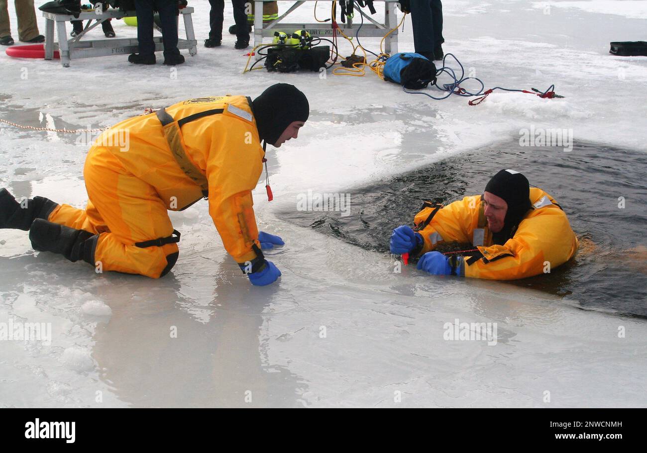 Firefighters wearing cold-water immersion protective suits hold surface ...