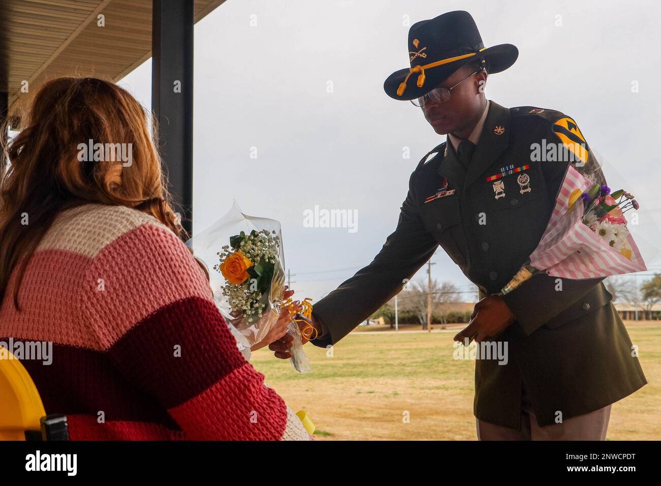 1st Cavalry Division Trooper presents flowers to Shari Rhoades, wife of ...