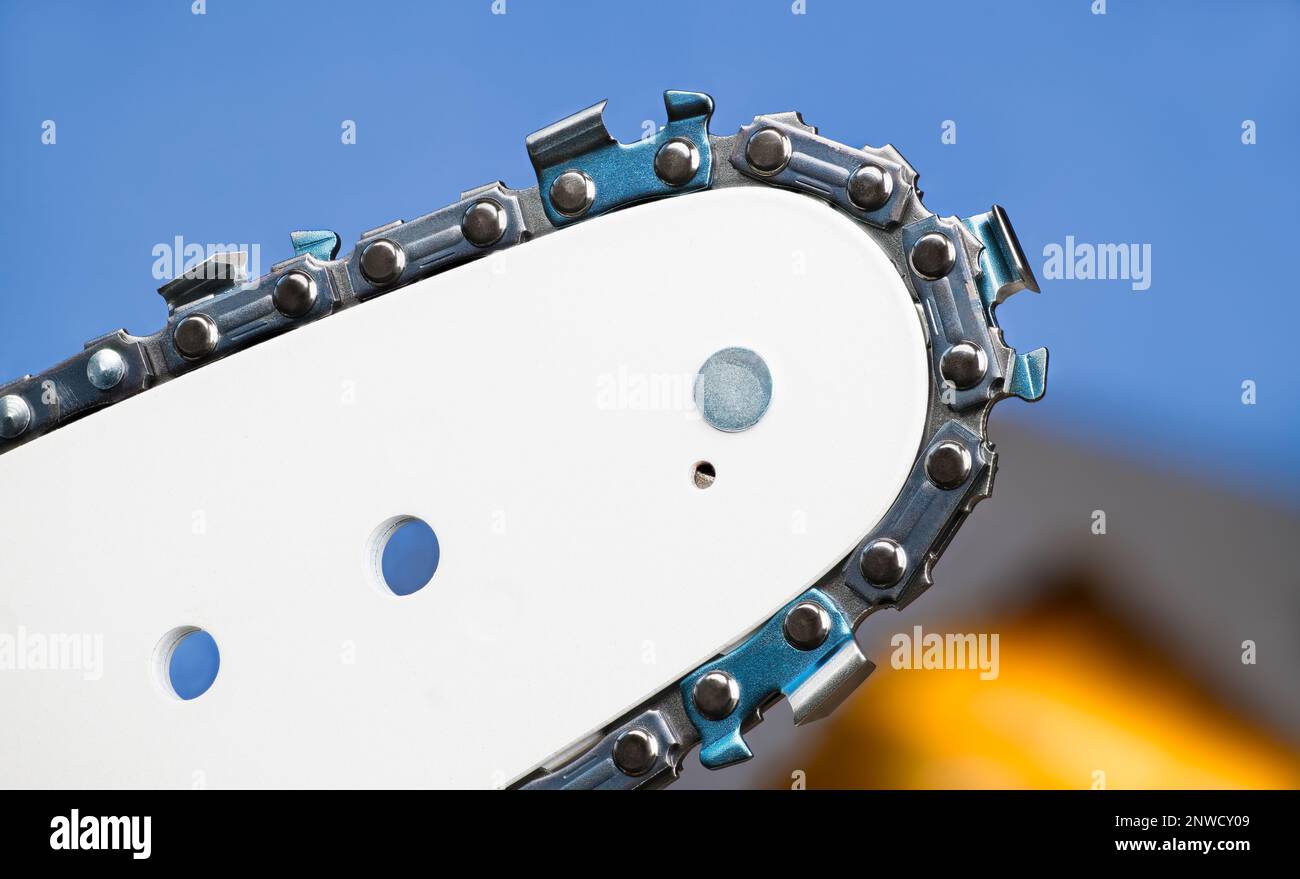 Chainsaw guide bar detail. Sharp teeth on shiny steel chain links with ...
