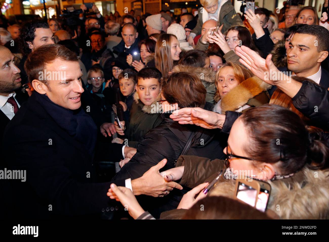 French President Emmanuel Macron shakes hands with people in the crowd ...