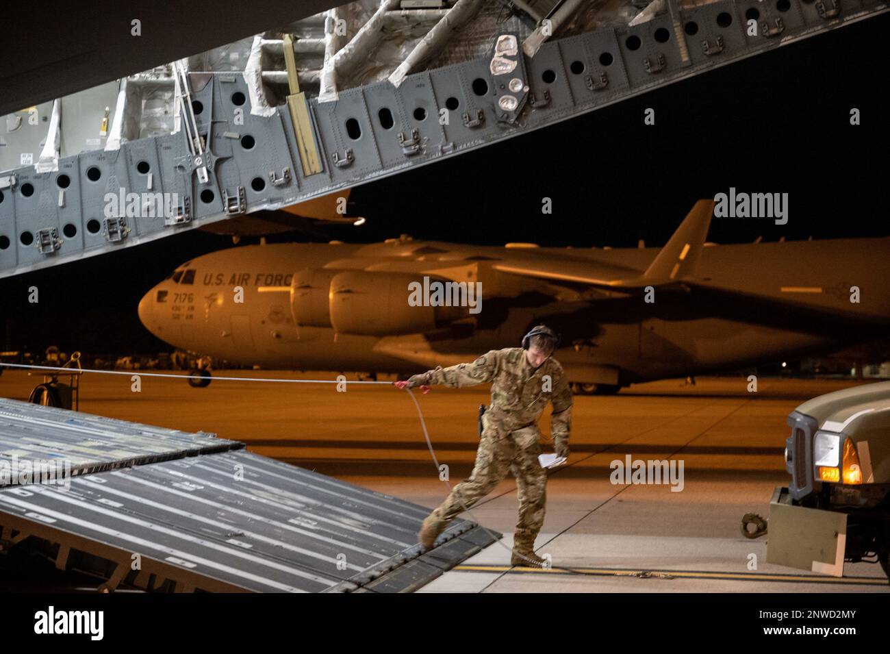 Senior Airman Matthew Warren, 3rd Airlift Squadron loadmaster, reels a ...