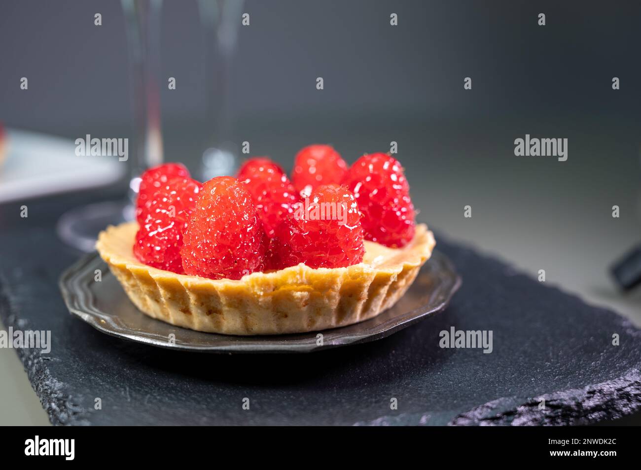 Artisanal baked small tart with cream and fresh ripe red raspberry ...