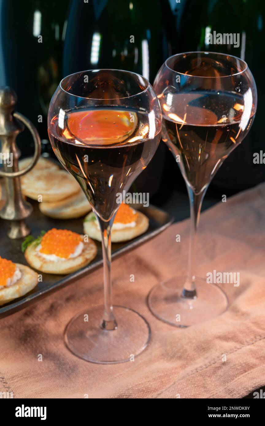 Tasting of rose Champagne sparkling wine with red caviar in cellars of ...