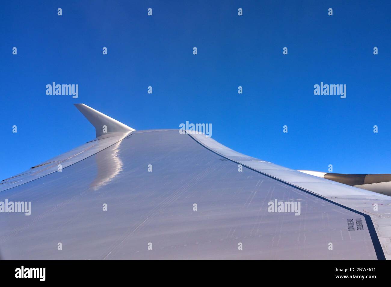 Wing and curved wing tip of a modern passenger jet in flight against a ...