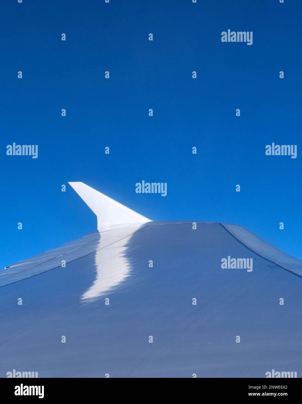 Wing and curved wing tip of a modern passenger jet in flight against a ...