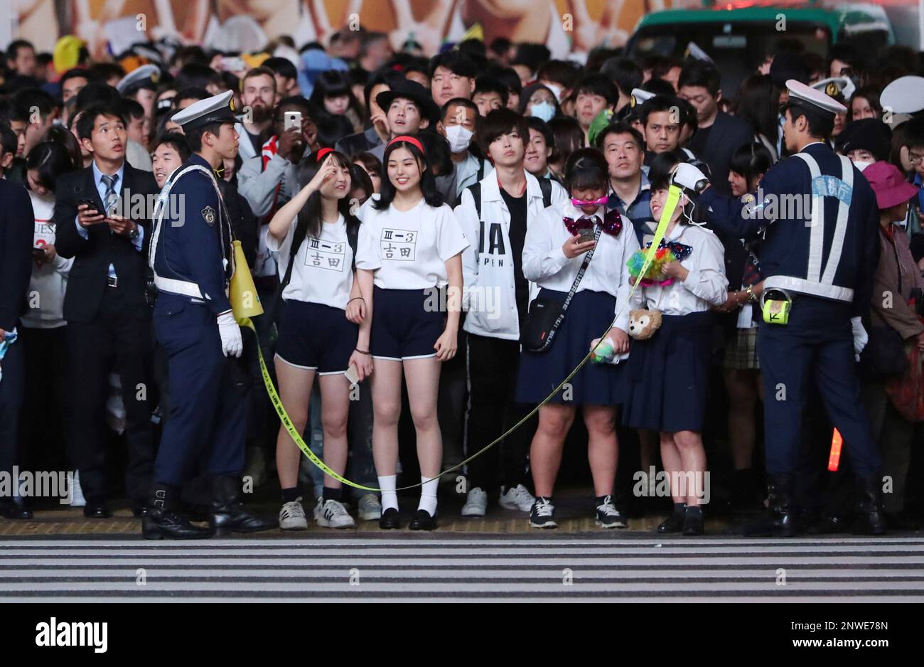 People dressed in Halloween costumes march around Shibuya Crossing or ...