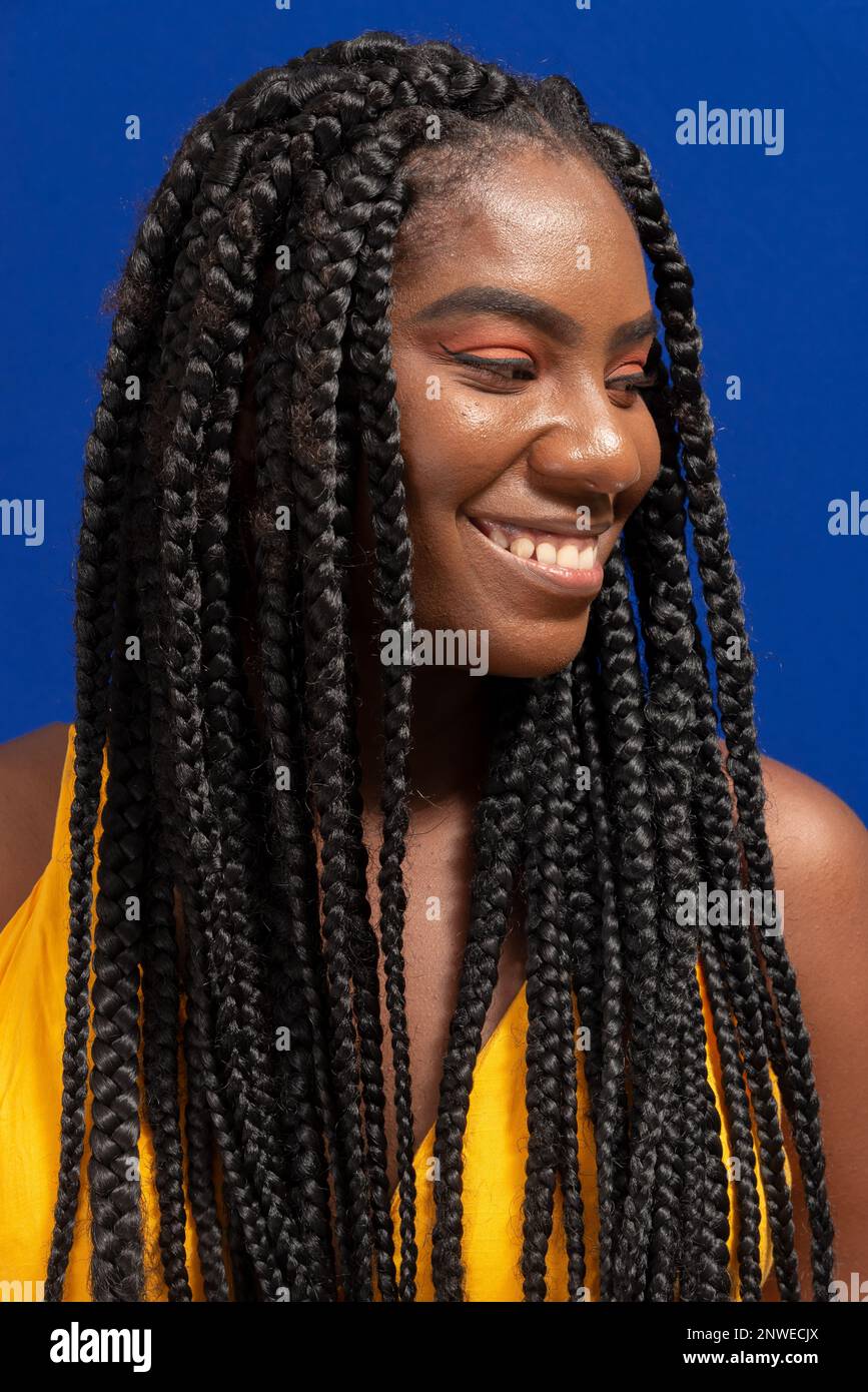 Beautiful young woman in vertical portrait against blue background ...