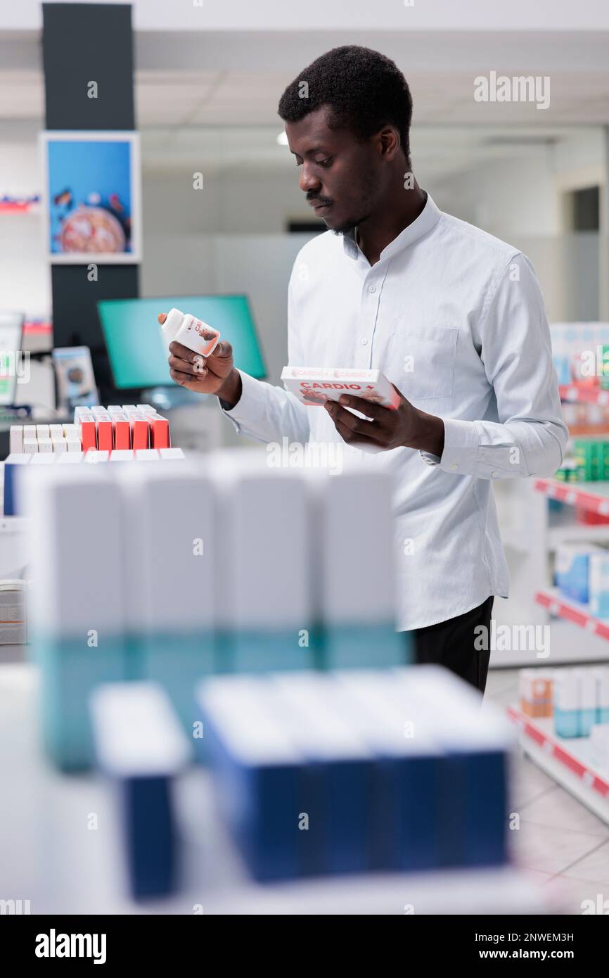 Young african american taking cardiovascular supplements from drugstore ...