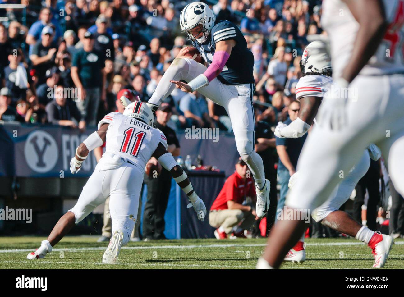 BYU quarterback Zach Wilson, center, hurdles Northern Illinois safety ...