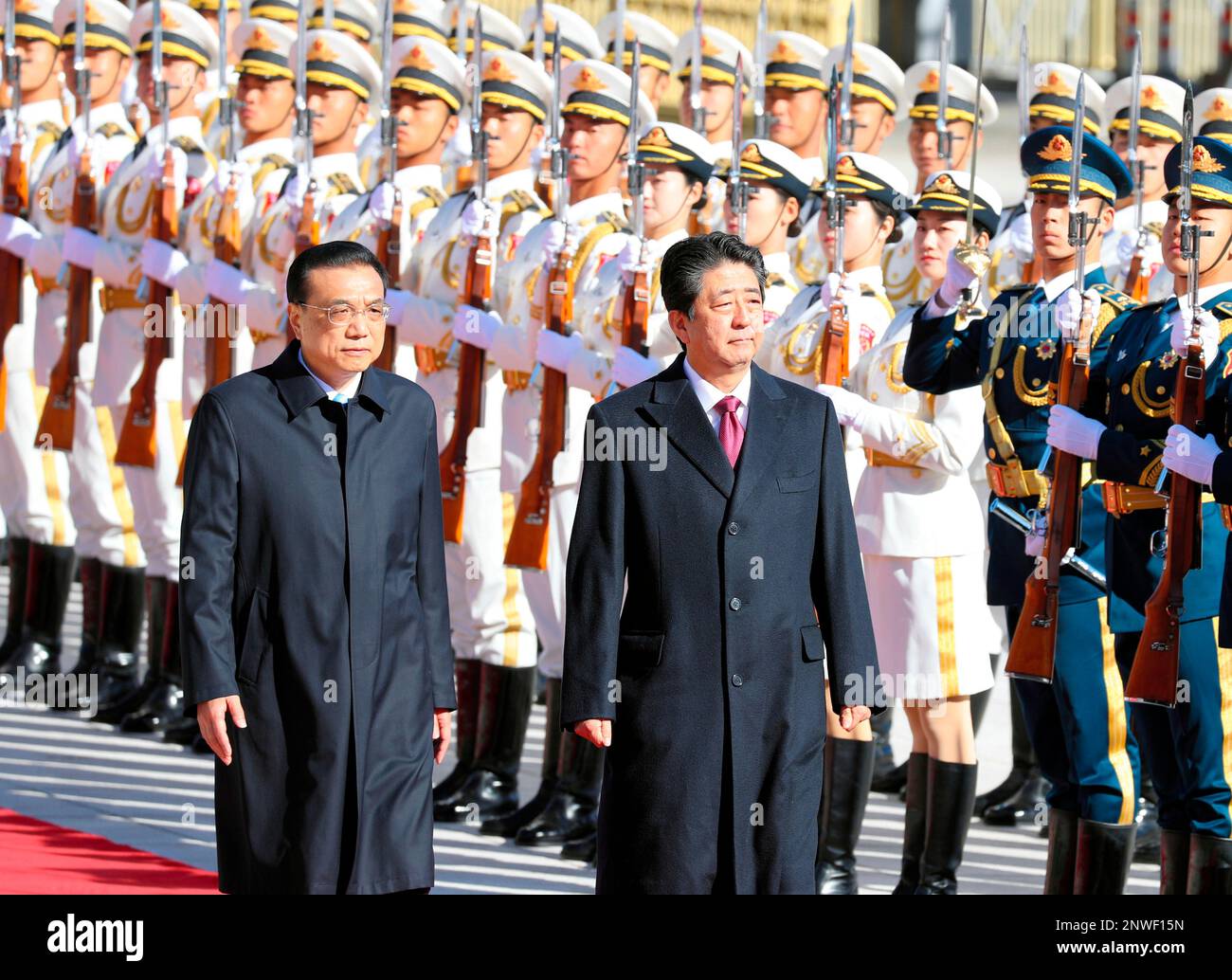 Japanese Prime Minister Shinzo Abe (R) escorted by Chinese Premier Li ...