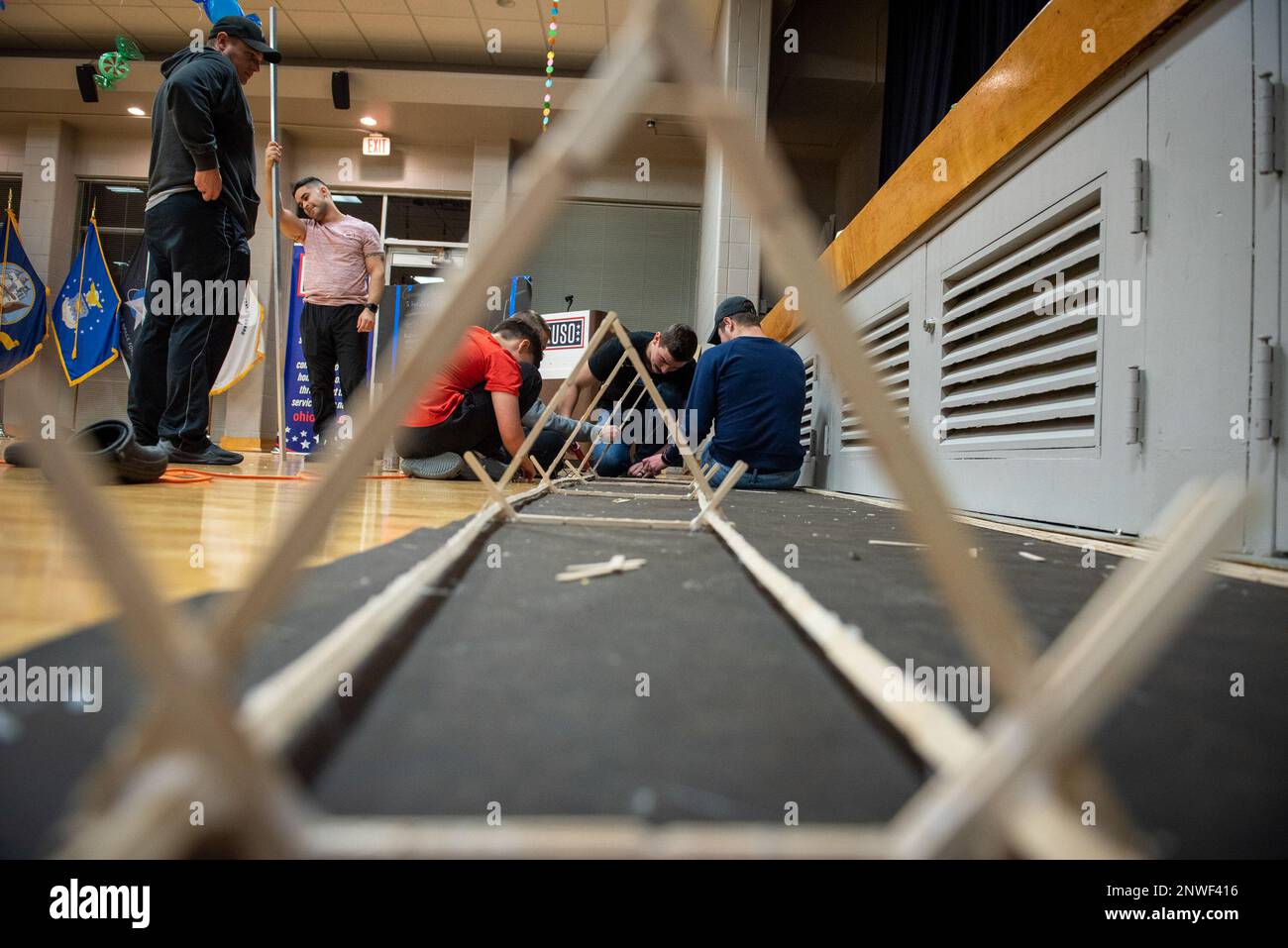 Volunteers attach support rings to the spire of a popsicle-stick ...