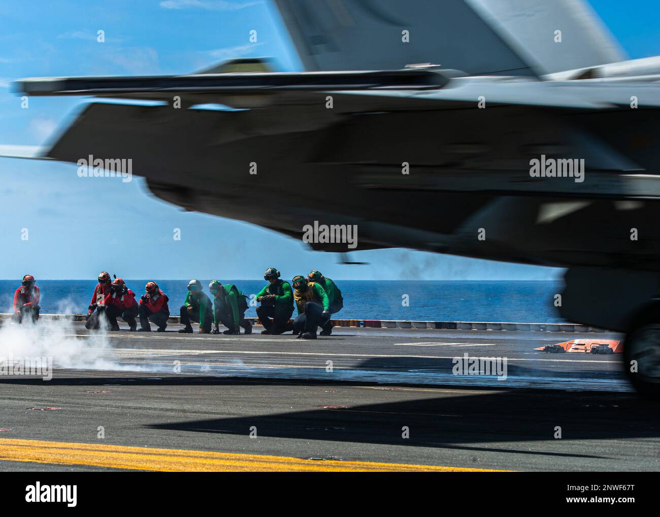 230217-N-MH015-2068 SOUTH CHINA SEA (Feb. 17, 2023) U.S. Navy Sailors observe an F/A-18E Super ...