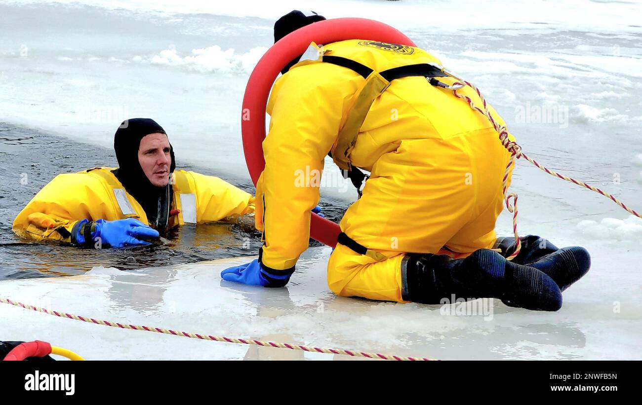Firefighters wearing cold-water immersion protective suits hold surface ...
