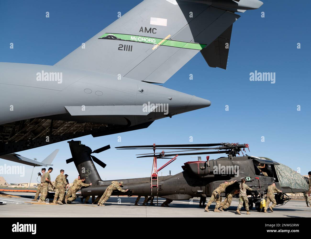 U.S. Airmen and Soldiers offload an AH-64D Apache Longbow helicopter ...