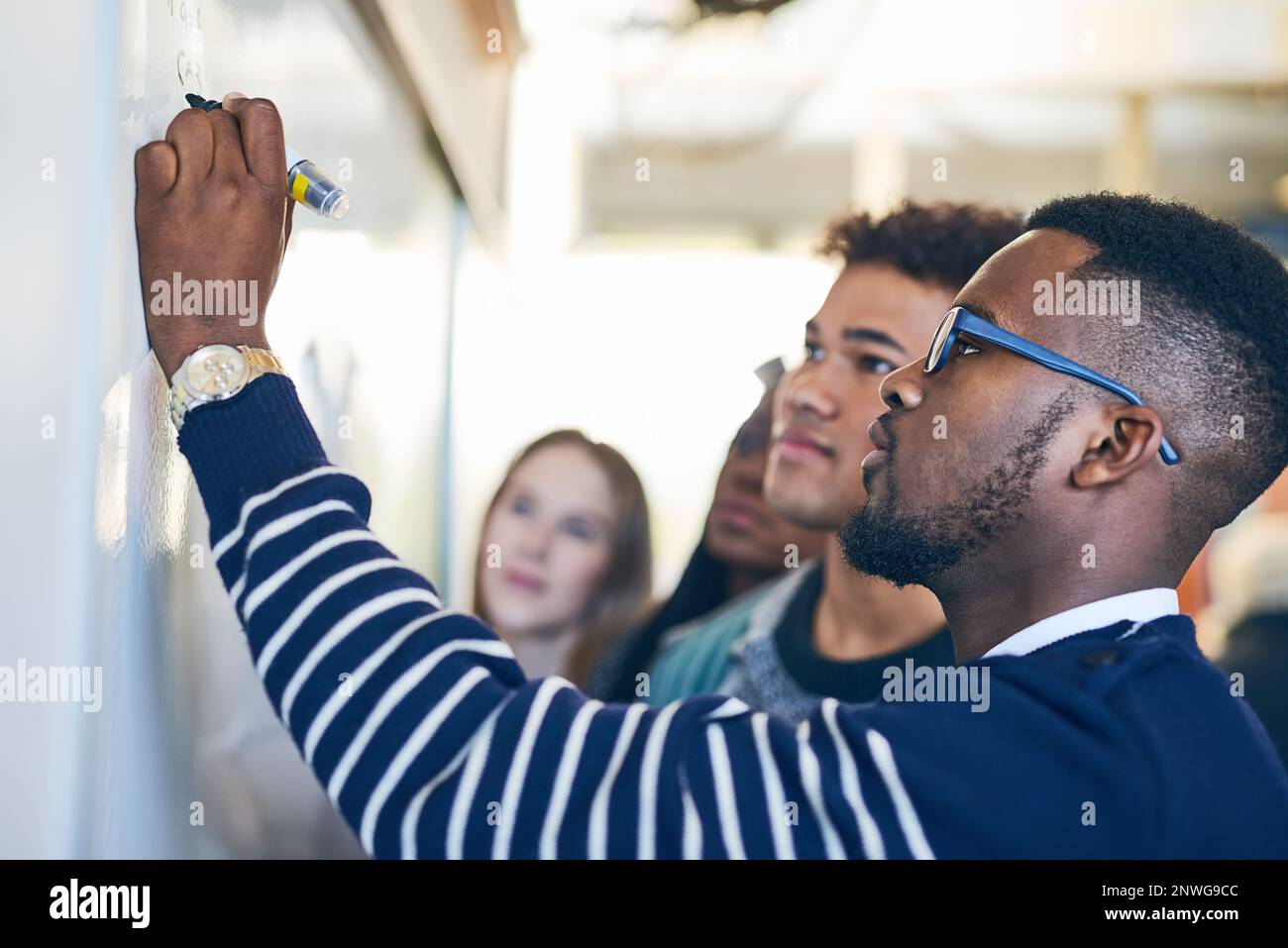 He takes his maths class serious. Shot of a young man writing on a ...