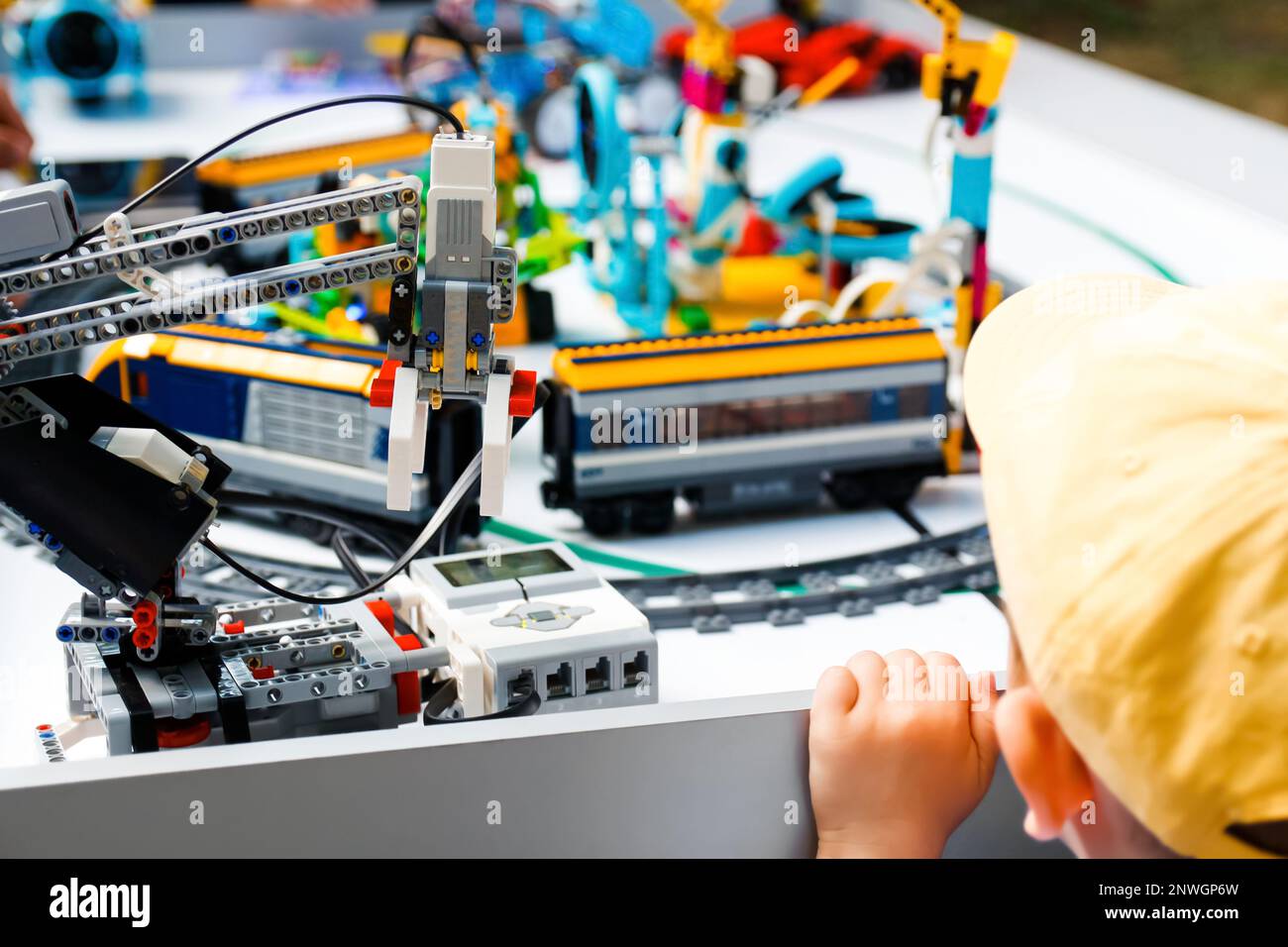 Robot constructor. Defocus little boy made robots on table. Train an ...