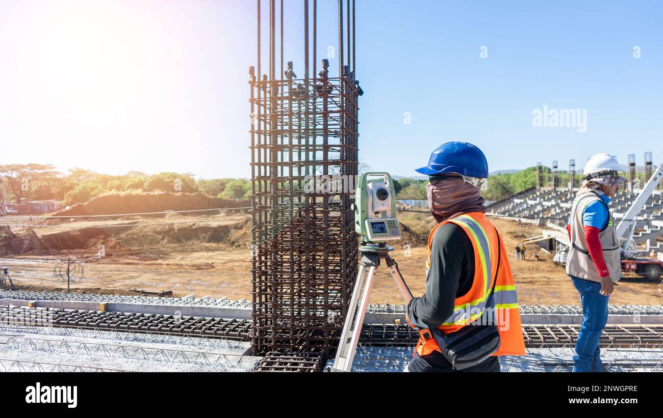 A Latino topographer measures the elevation and contours of a land area ...