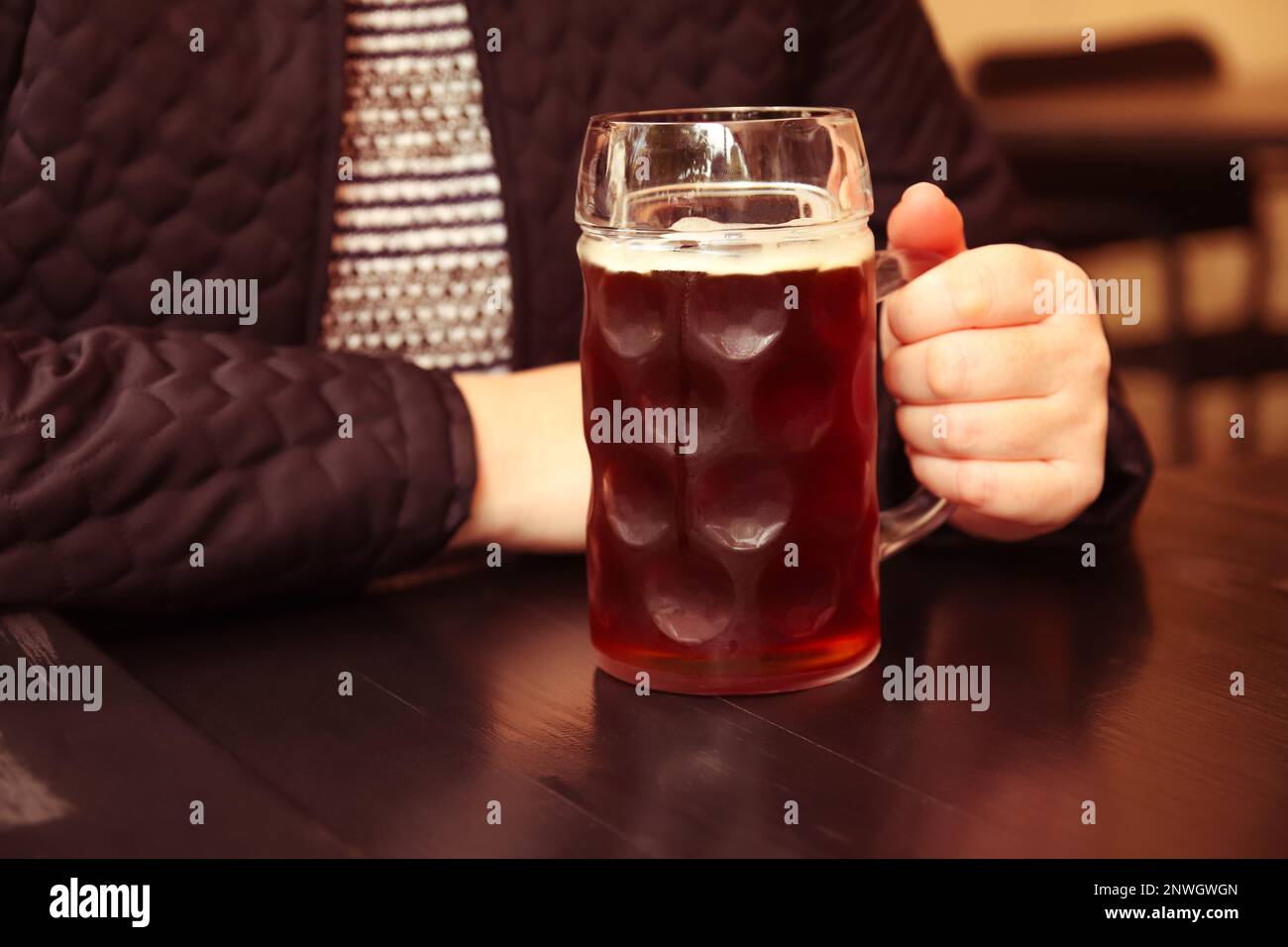 Dark beer. Defocus mug of dark beer. Closeup of two hands clinking beer ...