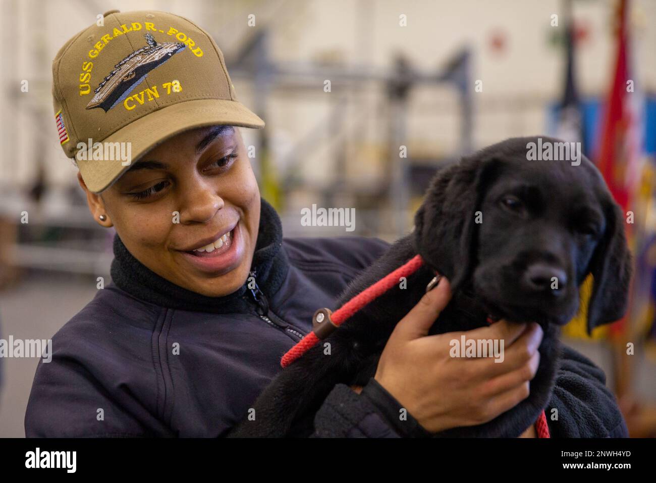 Seaman Tahaja Wilson, from Norfolk, Virginia, holds a dog, assigned to ...