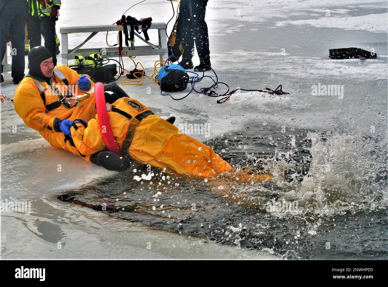 Firefighters wearing cold-water immersion protective suits hold surface ...
