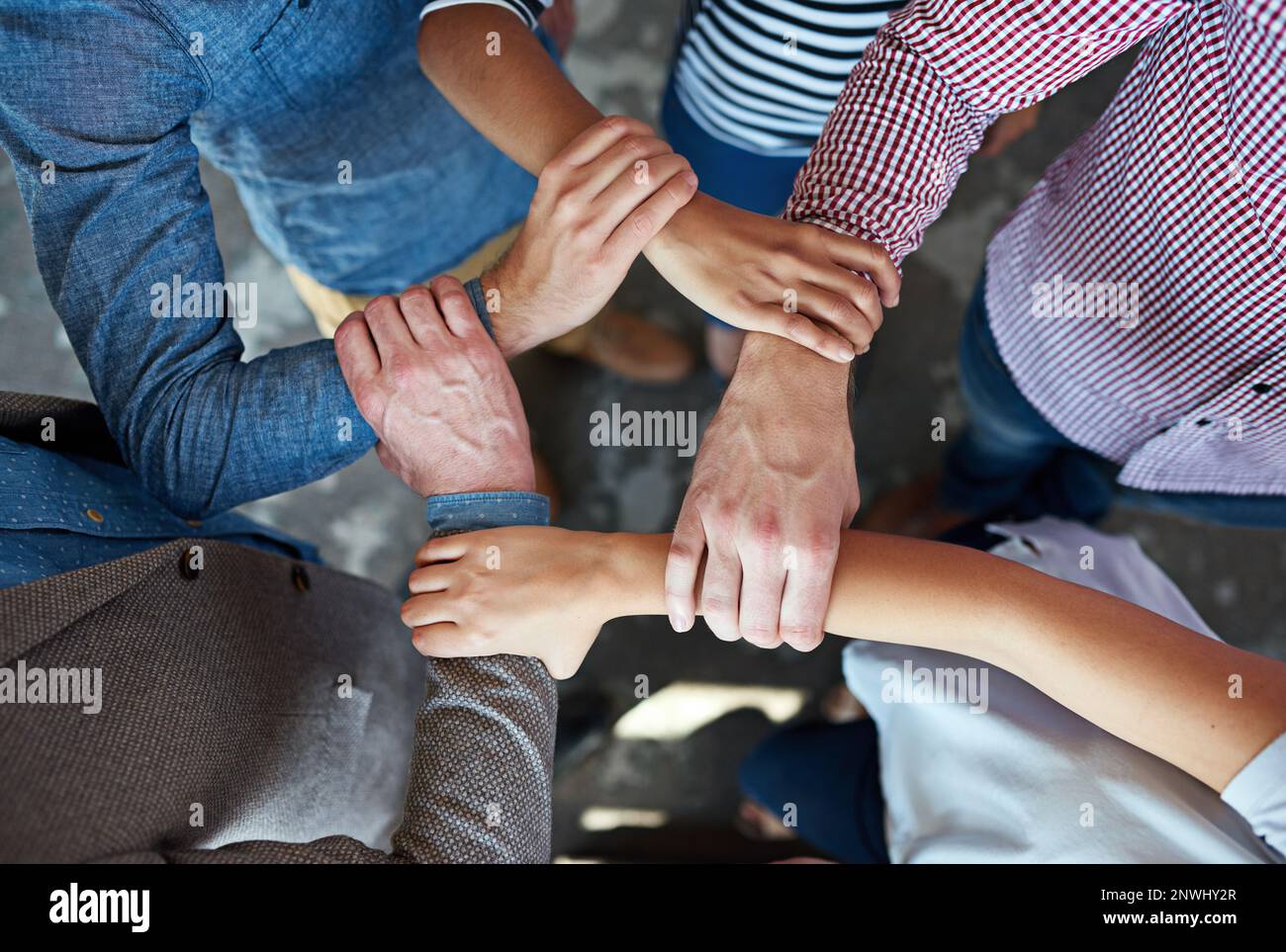 United we stand. Top view of co-workers hand put together in an ...