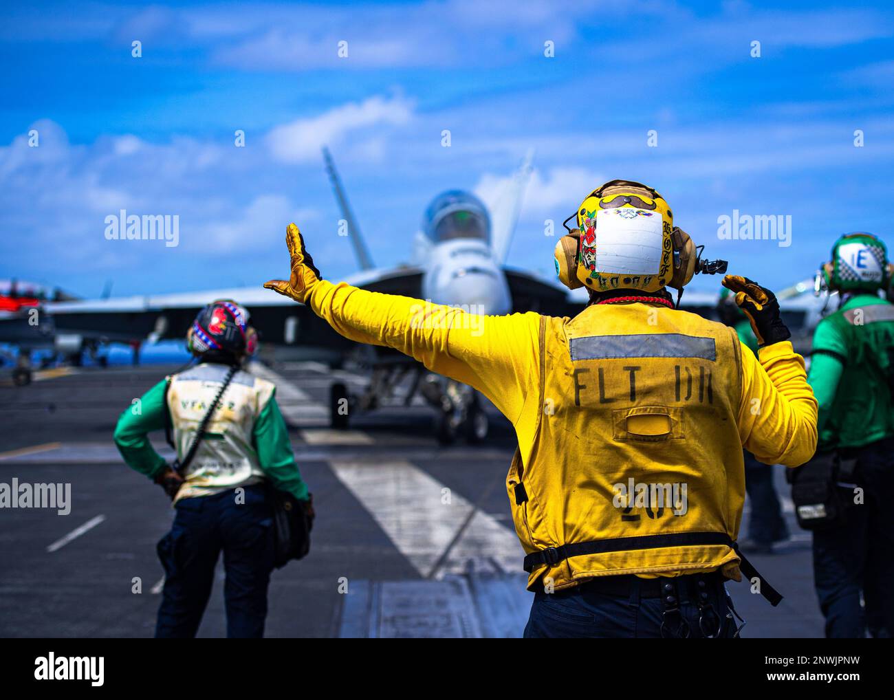 230224-N-MH015-2021 PHILIPPINE SEA (Feb. 24, 2023) A U.S. Navy Sailor directs an F/A-18F Super ...