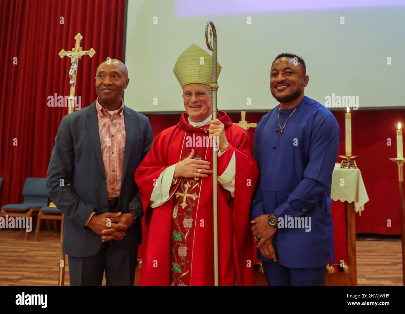 Roman Catholic Archbishop Timothy Broglio poses between a confirmand ...