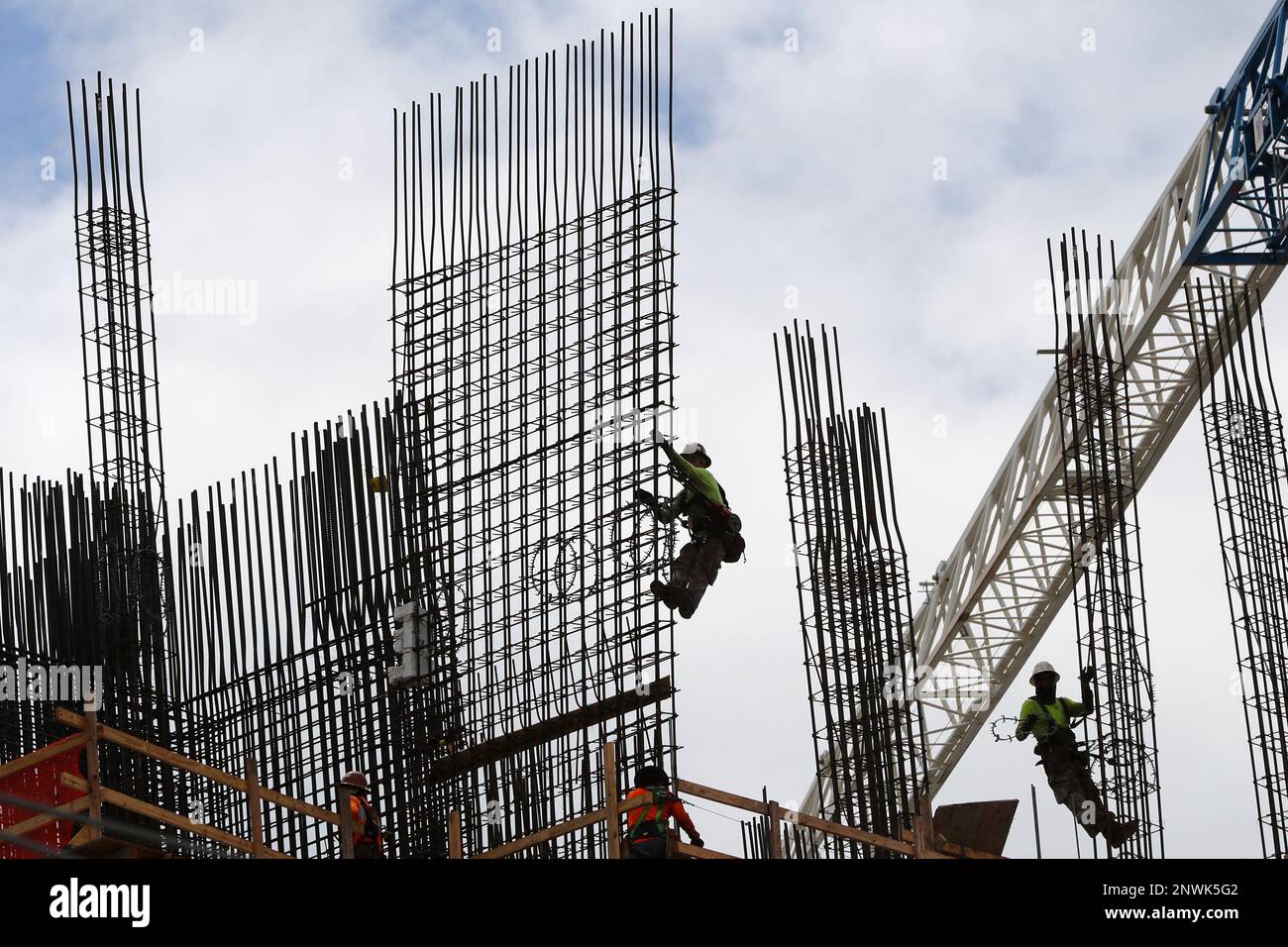 Metal workers are silhouetted on the top of The Rise, a luxury ...