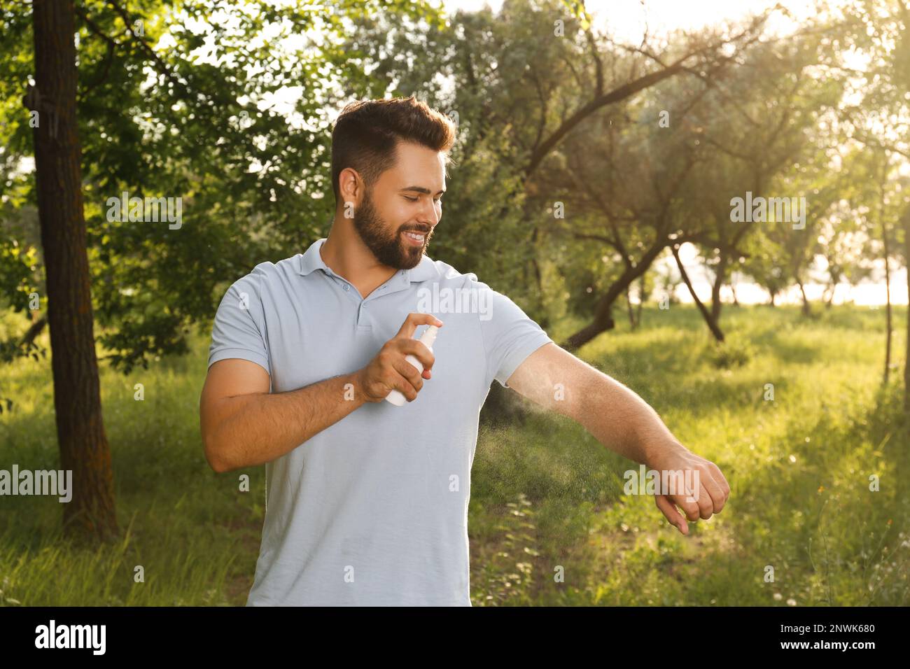 Man applying insect repellent on arm in park. Tick bites prevention ...